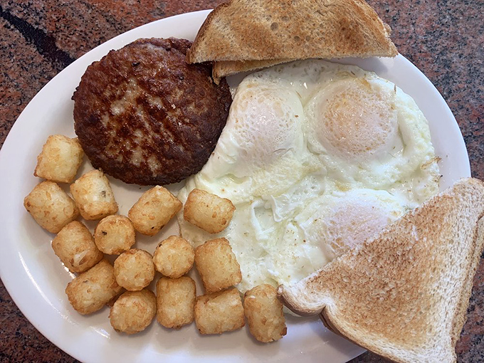 A breakfast platter that means business—eggs, sausage patty, and those famous Twig Taters forming a holy trinity of morning satisfaction.
