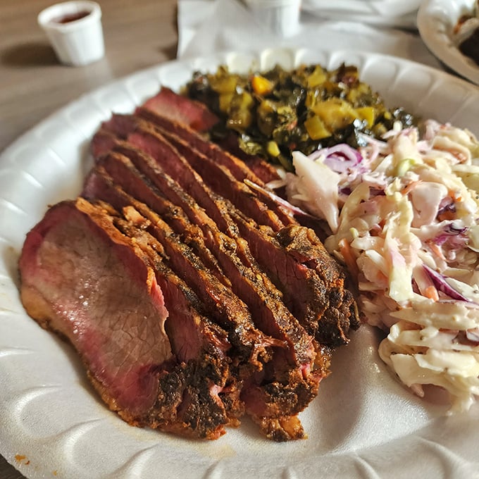 Slices of brisket with that telltale pink smoke ring – the barbecue equivalent of a gold medal. Paired with coleslaw and vegetables for a perfect plate.