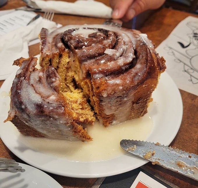 This cinnamon roll isn't just big – it's the "needs its own zip code" kind of massive, with swirls of cinnamon and glaze pooling beneath.