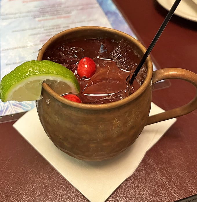 A Moscow Mule that knows how to dress for the occasion—copper mug, lime wedge, and those cherries adding a pop of color like tasteful jewelry.