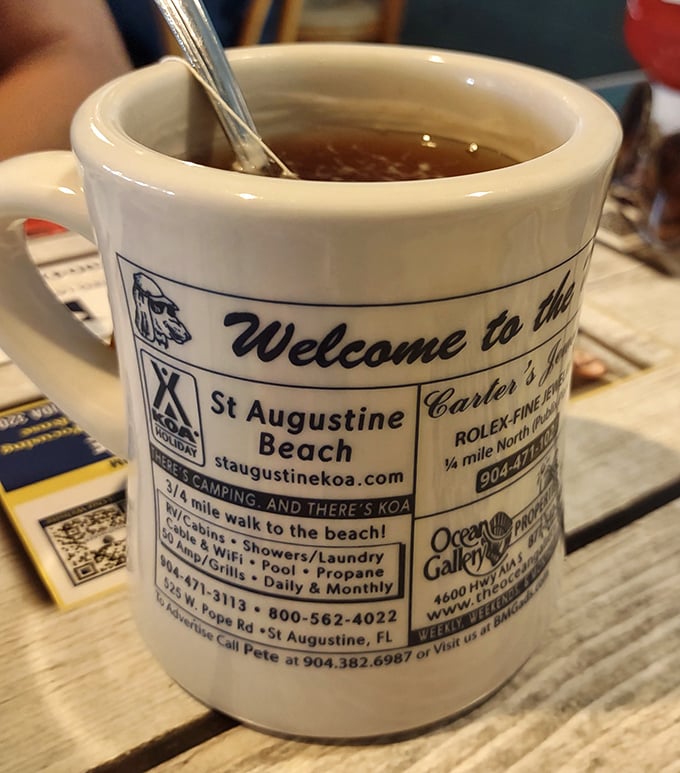 Coffee served in a mug that doubles as a St. Augustine Beach souvenir – multitasking at its finest.