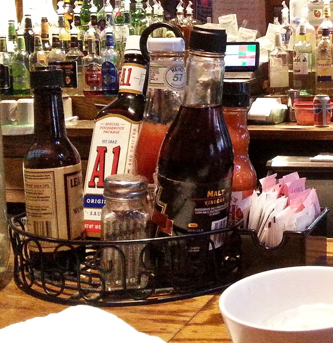 That condiment caddy is like a spice library for your burger—A1 and malt vinegar standing by for emergency flavor deployment.