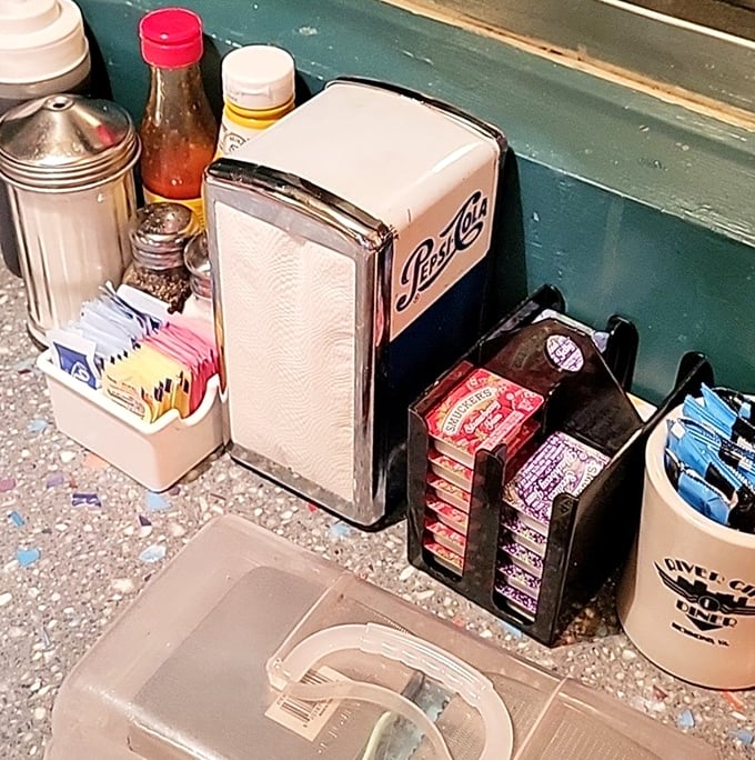 Every table's little civilization center—napkins, sweeteners, and that classic metal napkin dispenser that's somehow survived decades of technological advancement.