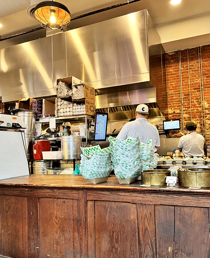 Where the magic happens—stainless steel meets brick walls in a kitchen that respects the craft. Like watching artisans at work.
