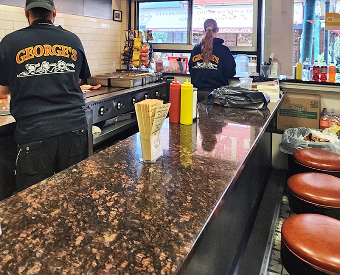 Behind this counter, sandwich artisans perform their daily magic. The marble top has witnessed more culinary triumphs than most five-star kitchens.