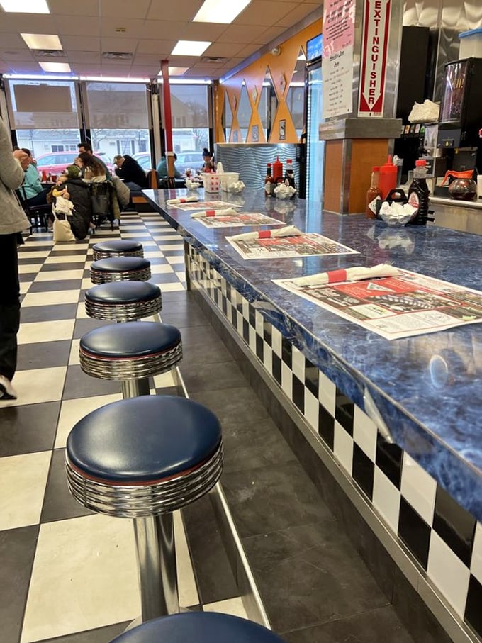 Counter culture at its finest—where newspapers meet coffee cups and strangers become temporary breakfast companions united by hunger.