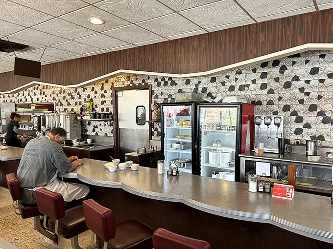 Black and white mosaic meets classic counter culture. The curved lunch counter—where solo diners find community over coffee.