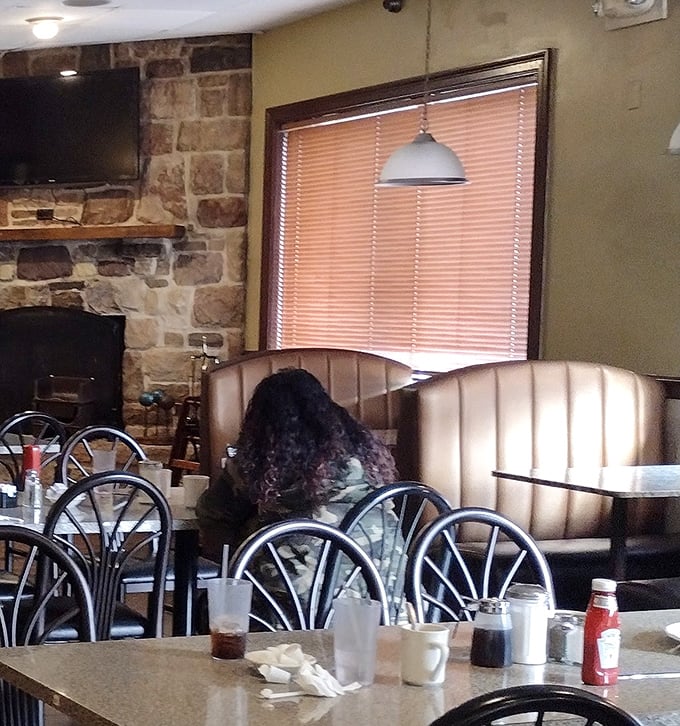 The stone fireplace adds rustic charm to comfortable booths where countless conversations and comfort food memories have been made.