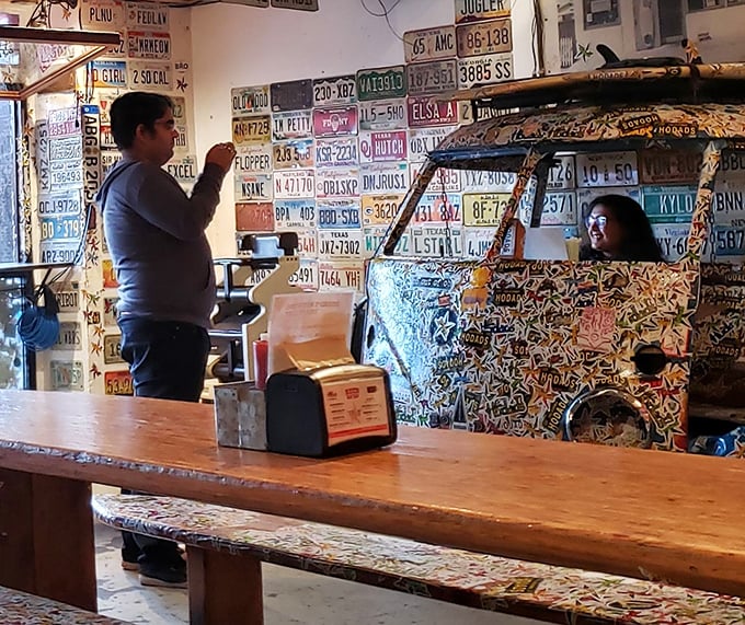 Inside Hodad's, where license plates become wallpaper and VW buses become décor. Even the furniture is having more fun than at your house.
