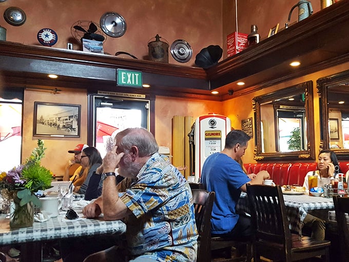 Where breakfast memories are made—regulars chat while vintage gas station collectibles watch from their perch above the cozy dining room.
