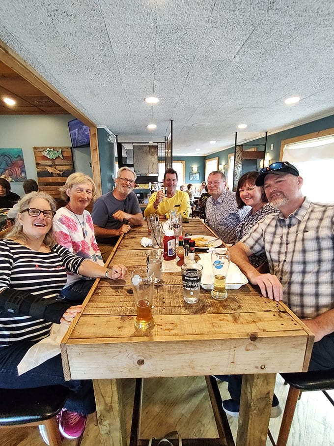 Happy diners gathered around rustic wooden tables—proof that great food creates instant community. These folks aren't just eating; they're making memories.