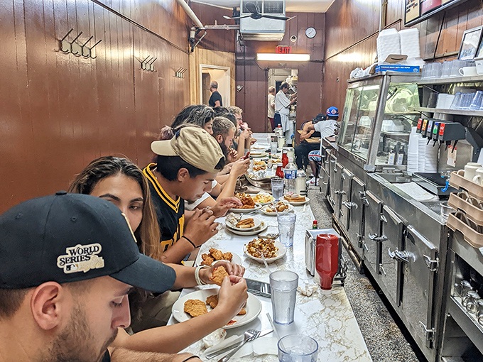 The narrow counter fills with hungry patrons at all hours—a cross-section of Detroit united by the universal language of good food.