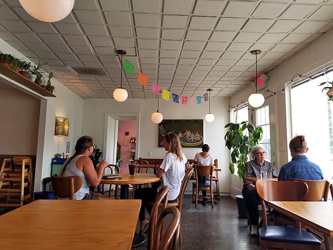 The true measure of a great café: people lost in conversation, savoring both the food and the moment, under cheerful papel picado banners.