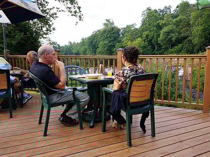 Outdoor dining with a creek view – because food tastes better when birds might steal your fries.