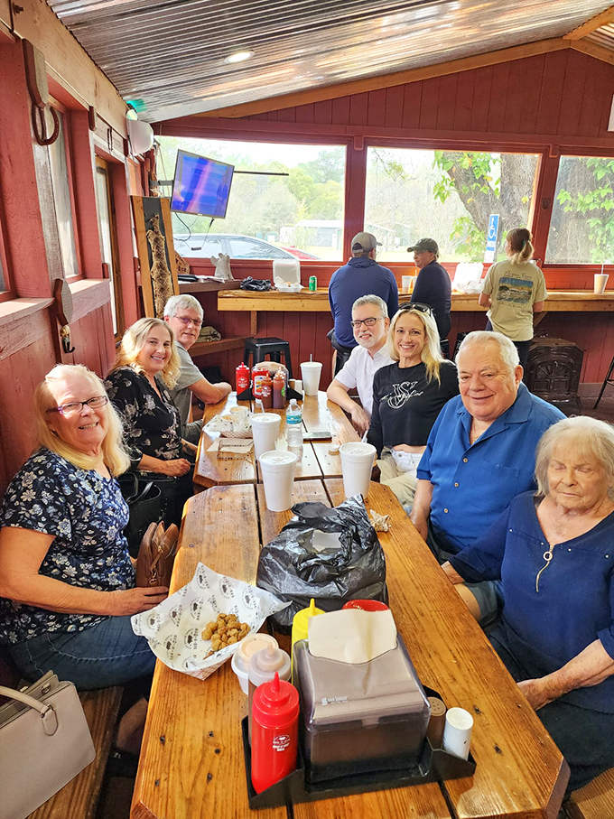Happy faces around a picnic table—the universal sign of BBQ done right. No phones in sight, just people living in the moment, connected by smoke and sauce.