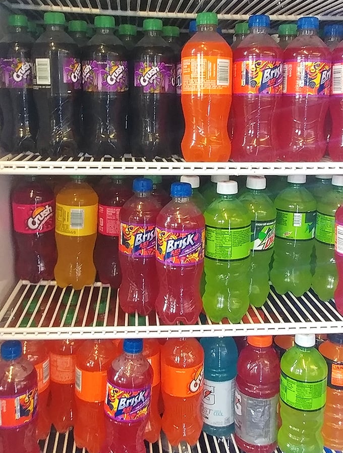 The beverage cooler—a rainbow of liquid refreshment options standing ready to combat the thirst that inevitably follows sandwich perfection.