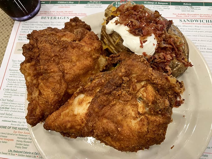 Golden-brown fried chicken pieces rest beside a loaded baked potato, proving some classics never go out of style.