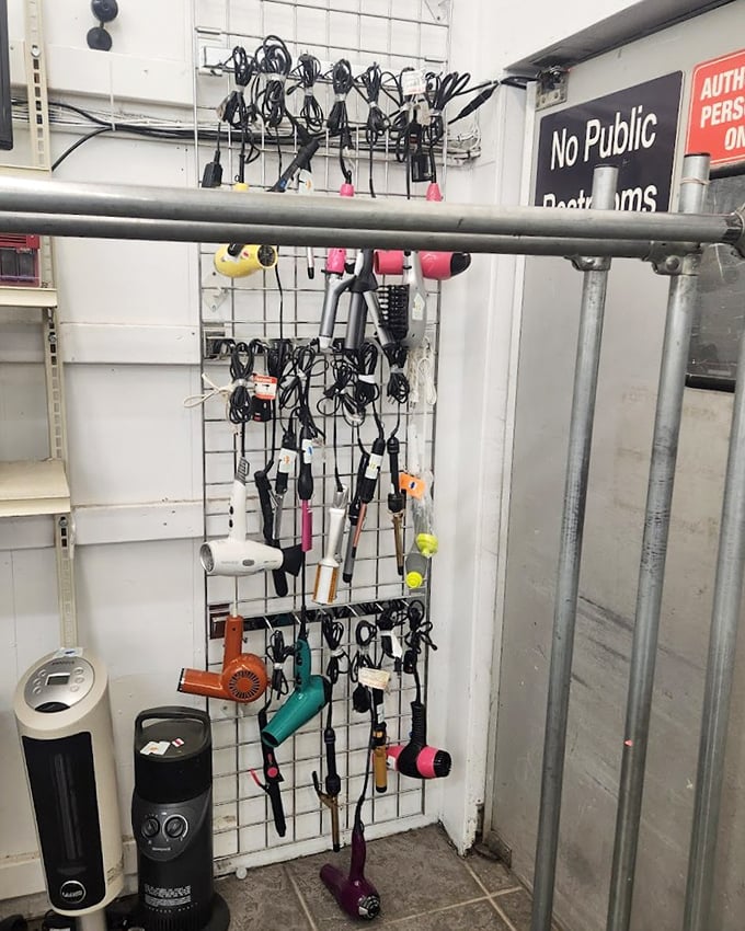 A wall of forgotten electronics and styling tools—technological time capsules hanging in suspended animation. Yesterday's innovations waiting for tomorrow's nostalgic collector.