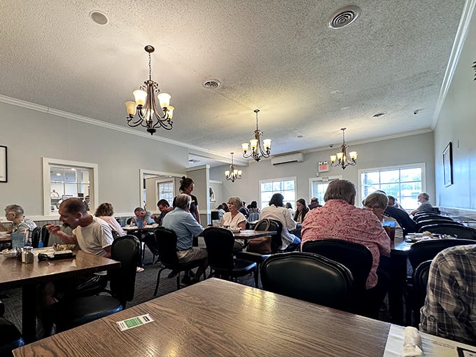 Multiple chandeliers casting their glow over happy diners – fancy enough to feel special, relaxed enough to breathe.