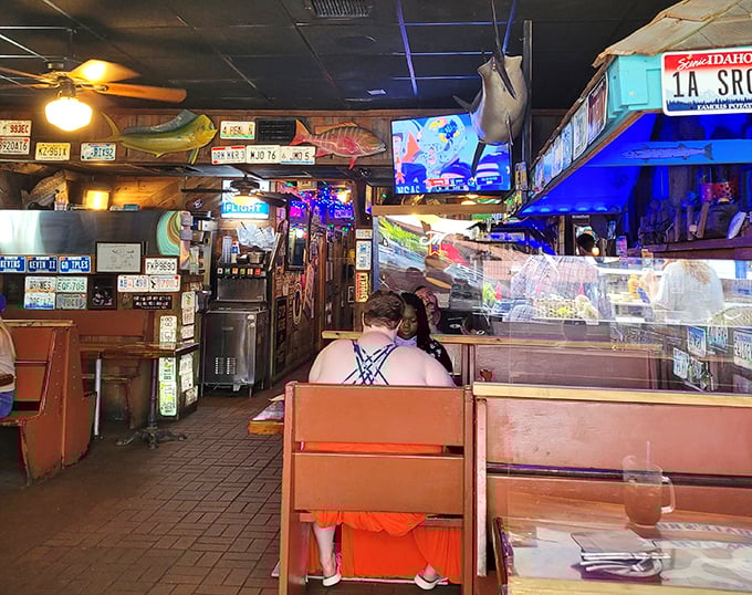 Wooden booths worn smooth by decades of elbows tell you this place has history – and the license plates tell you it has fans.