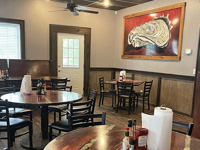 Rustic charm meets seafood shrine in this dining area. The oyster artwork watches over diners like a benevolent shellfish deity.