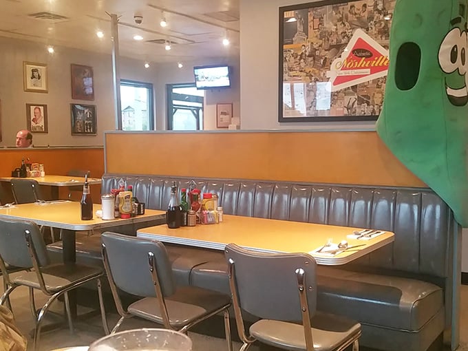 Silver-blue booths that have cradled countless conversations and food comas. The pickle mascot stands guard, ensuring no one leaves without experiencing proper deli magic.