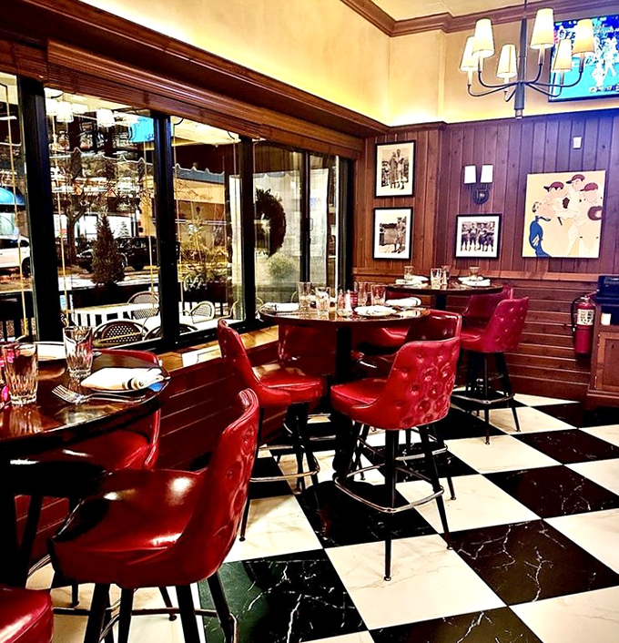 Black and white checkered floors meet red leather chairs—it's like a chess game where everyone wins with good food.