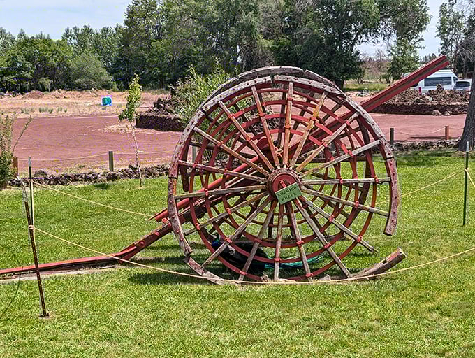 The weathered wooden wheel stands sentinel, a relic from Oregon's logging past that found retirement among the stone fantasies.