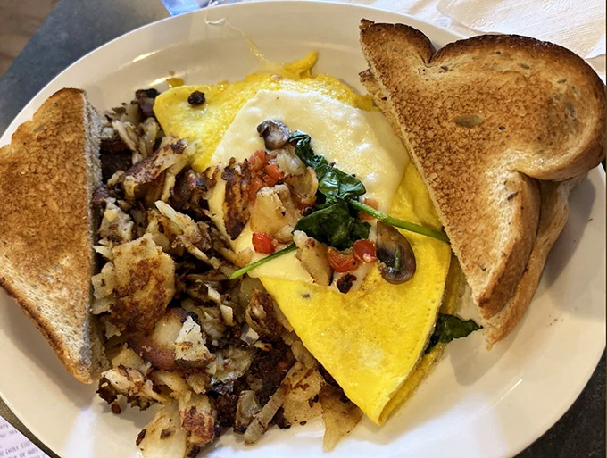 This omelet doesn't just contain vegetables—it embraces them in a fluffy yellow blanket of breakfast bliss.