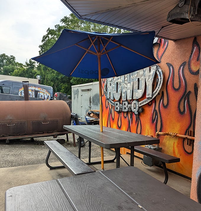 A flame-painted wall, blue umbrella, and picnic tables – the outdoor dining area is BBQ's version of al fresco elegance.