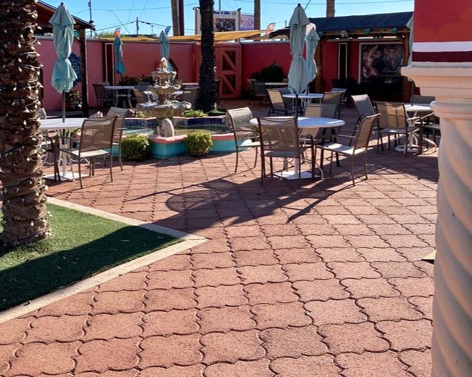 A fountain creates the soundtrack for this peaceful courtyard dining space. The pink walls aren't just a color choice—they're a mood-enhancing design decision.