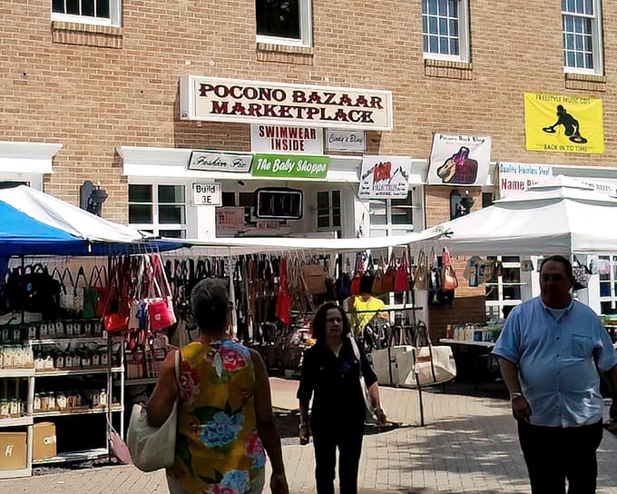 The outdoor market buzzes with activity as shoppers hunt for treasures under protective tent canopies.
