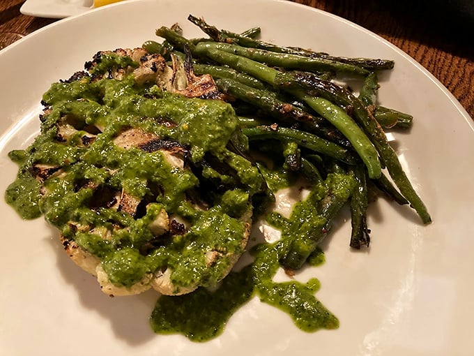 Pesto-crusted protein with grilled vegetables—proof that green sauce makes everything taste like it just won a culinary medal.