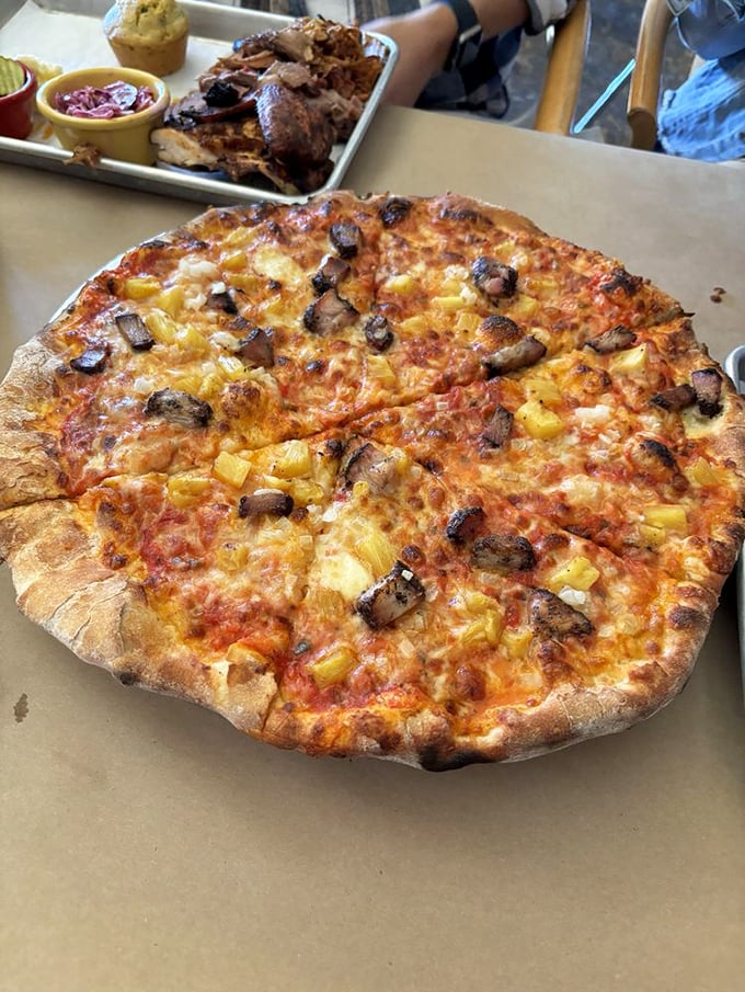 Wood-fired pizza topped with smoky brisket and pineapple—a combination that somehow makes perfect sense when you're actually eating it.