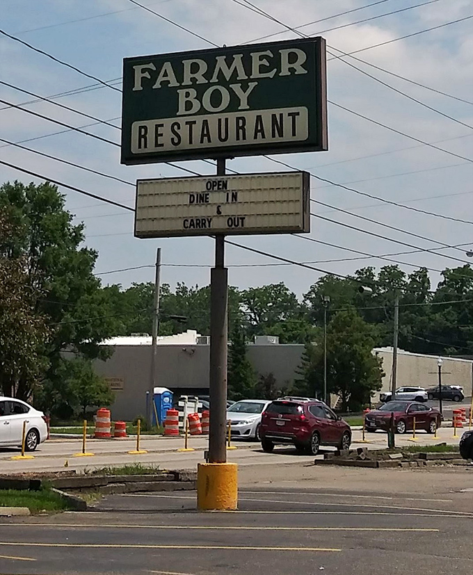 The roadside sign stands like a beacon of hope for hungry travelers. No fancy digital displays needed—just the promise of good food inside.