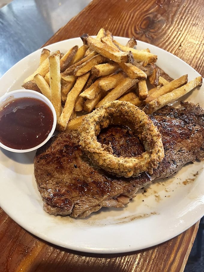A perfectly cooked steak with one magnificent onion ring—like Texas itself, straightforward, unpretentious, and absolutely unforgettable.