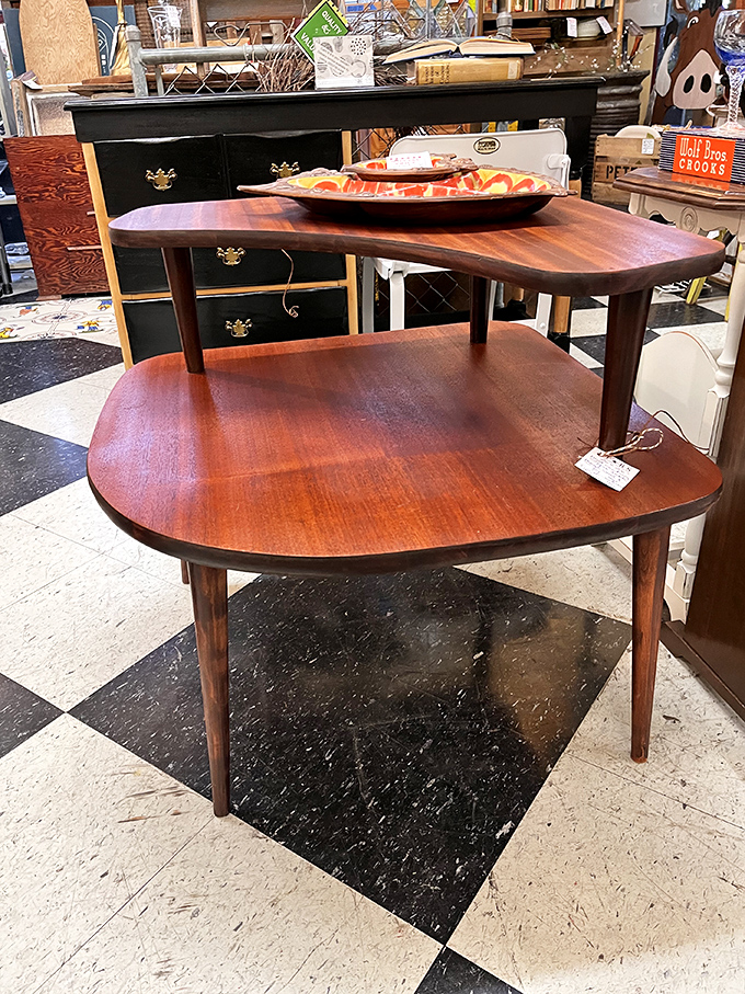Mid-century modern perfection in wood. This tiered table isn't furniture—it's functional sculpture that's survived decades of changing tastes.