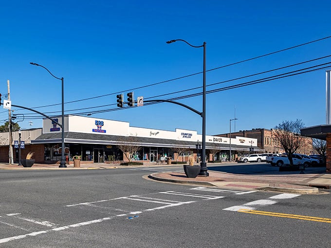 A sunny intersection showcases locally-owned businesses where residents find everyday necessities without the premium prices of larger cities.