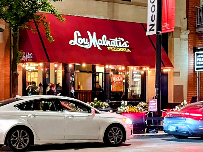 Lou Malnati's red awning glows like a pizza beacon in Chicago's theater district – showtime for your tastebuds.