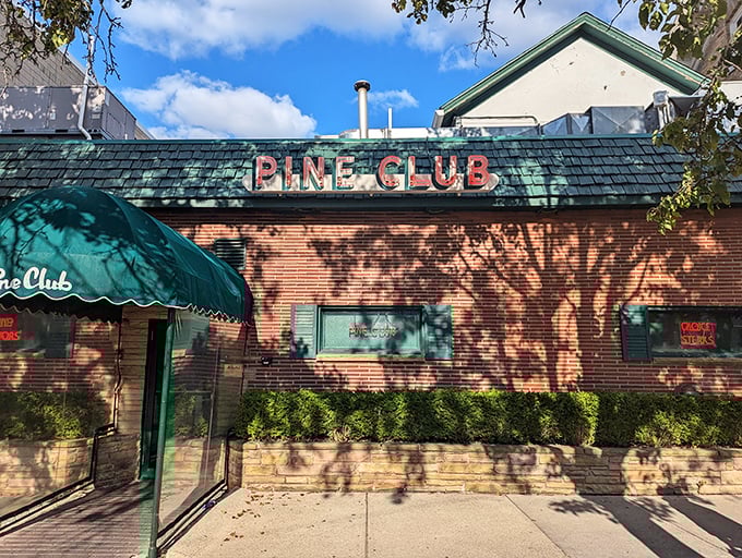 The Pine Club's brick facade and green awning – steakhouse perfection hiding in plain sight since the Truman era.