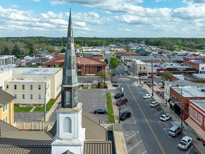 The view from above showcases Clanton's church spires reaching skyward—spiritual landmarks in a town where your retirement funds reach further too.