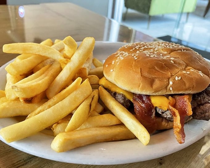 This isn't just a burger—it's a masterclass in American comfort food engineering. Melty cheese, crispy bacon, and fries that demand to be stolen.