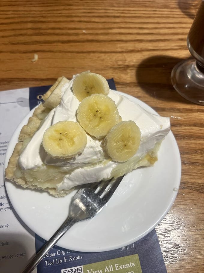 Banana cream pie that makes you want to write poetry. Fresh banana slices nestled in pillowy cream atop a flaky crust—simplicity at its most sublime.