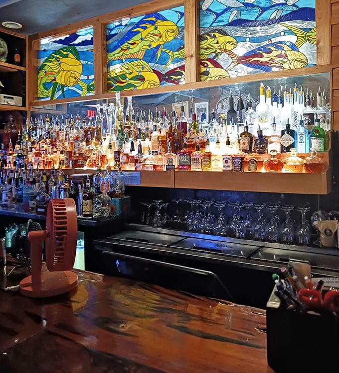 The bar's stained glass fish backdrop transforms ordinary cocktail hour into something magical—like drinking inside an aquatic kaleidoscope.