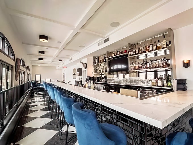 This isn't just a bar—it's a stage where liquid alchemy happens nightly. Those blue velvet stools are practically begging you to settle in for a Manhattan.