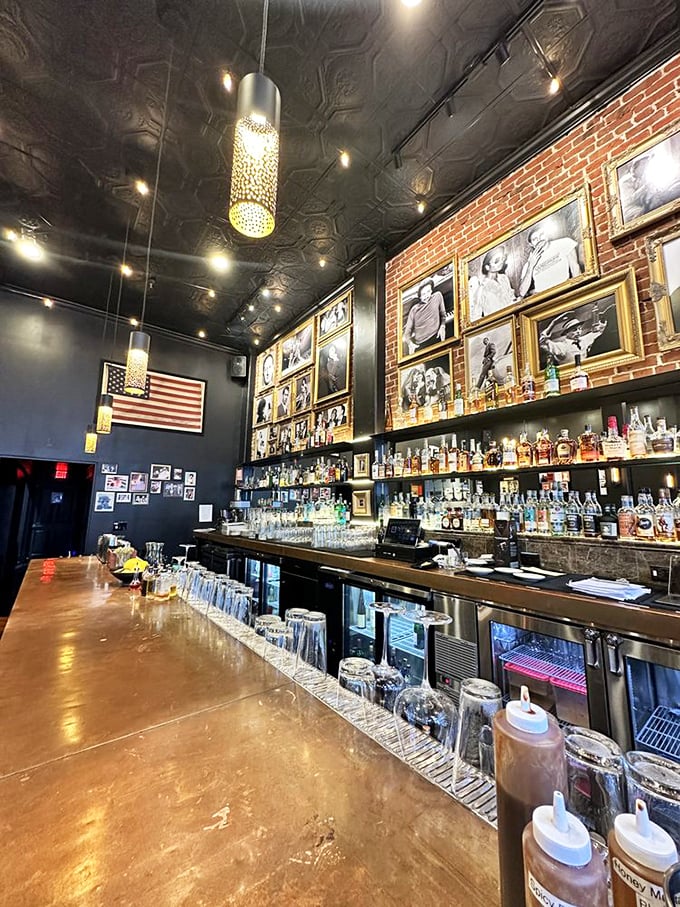 The bar wall gallery creates a shrine to American spirits. This isn't just where drinks are poured—it's where barbecue pilgrimages are celebrated.