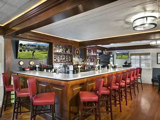 The bar area balances nautical charm with modern comfort—red leather stools invite you to settle in for a drink while watching the game or swapping stories with fellow travelers.
