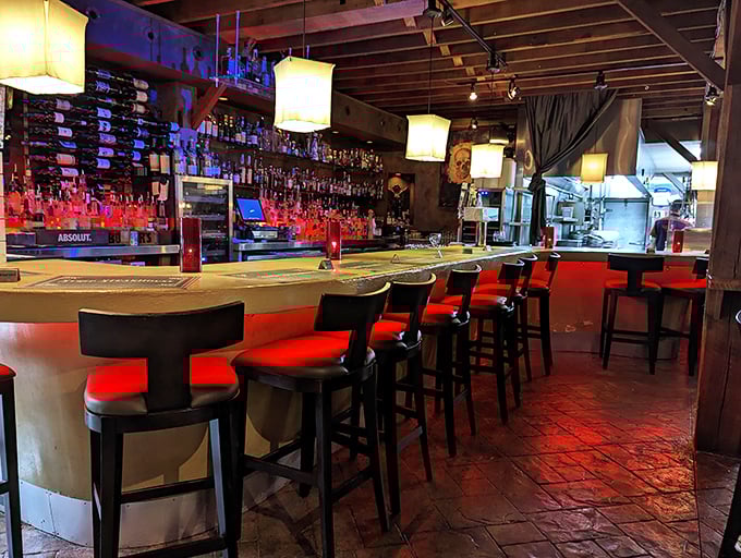 The bar glows with promise, its red-cushioned stools inviting you to perch and ponder life's important questions—like "Another round?"