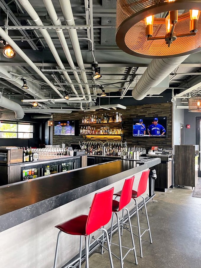 A bar that understands drinking is a social sport. Those red chairs aren't just seating—they're invitations to stay longer than you planned.