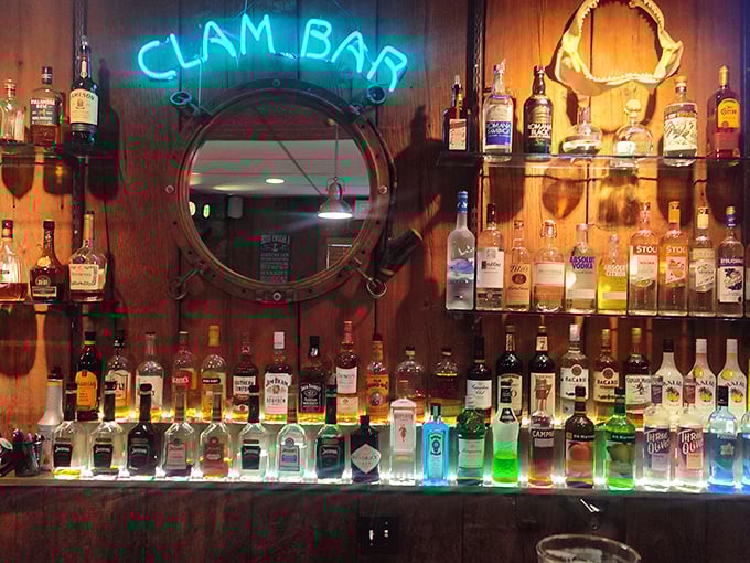 The "Clam Bar" sign glows like a blue beacon above bottles standing at attention, ready to complement your seafood adventure.